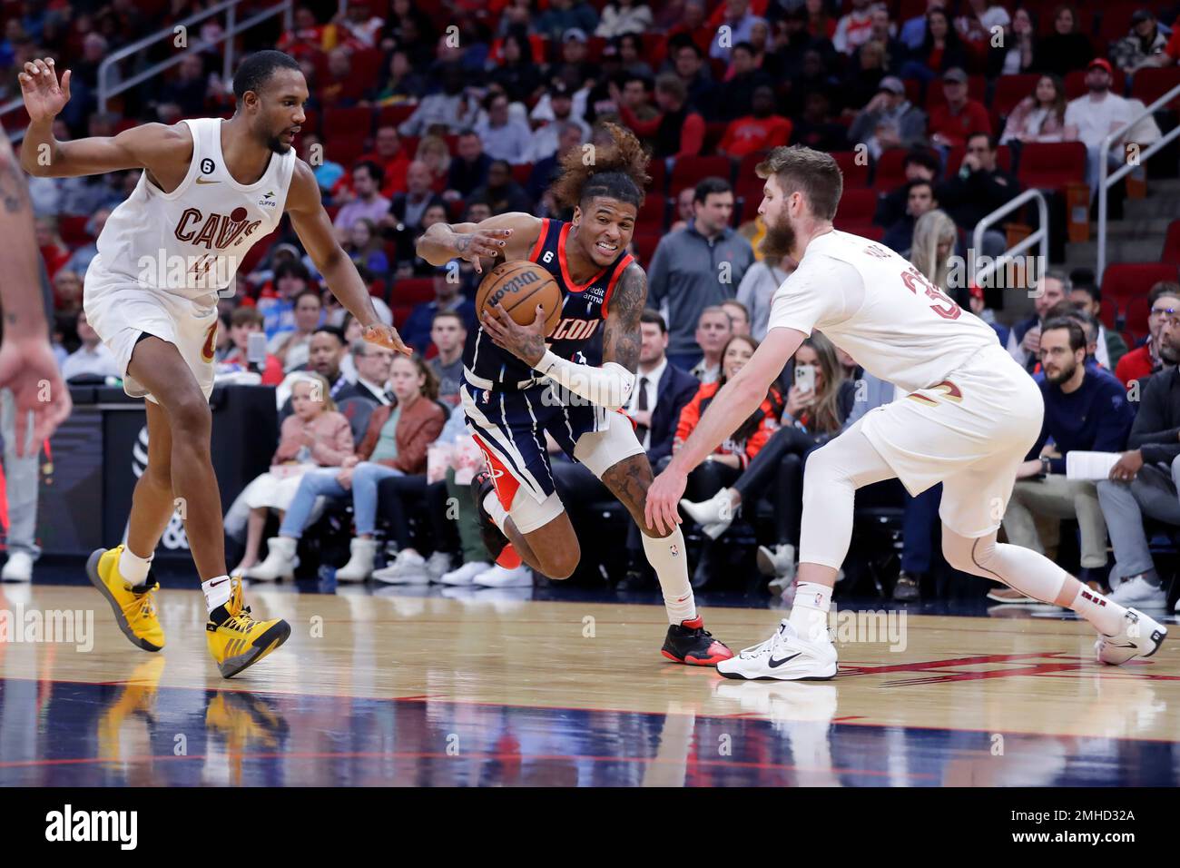 Houston Rockets guard Jalen Green, center, drives between Cleveland ...