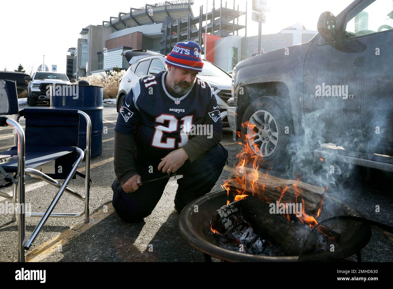Marc Folsom, of Bristol, N.H., builds a fire while tailgating in the ...