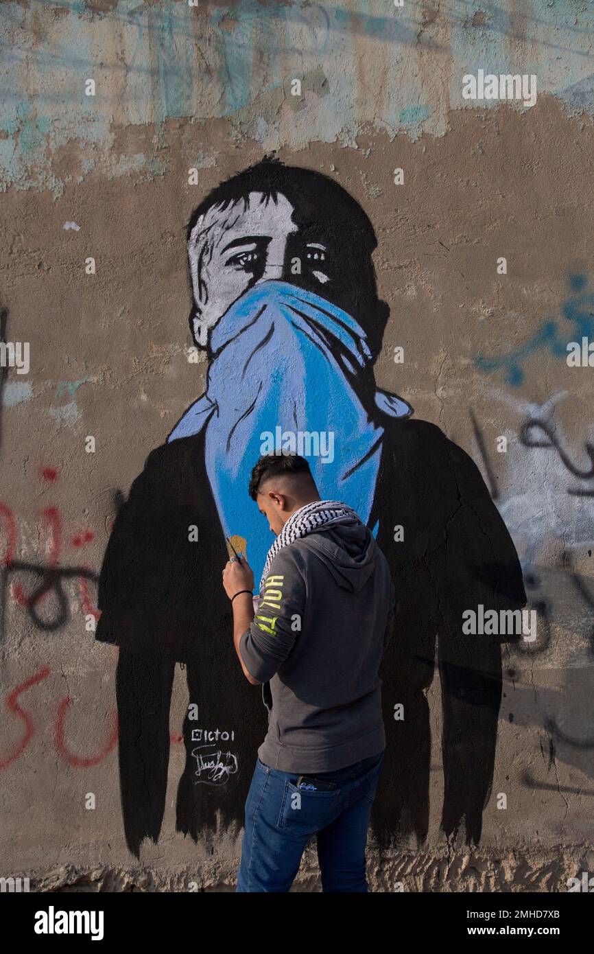 Iraqi street artist Mustafa Mashal, 22, works on a mural in Baghdad ...