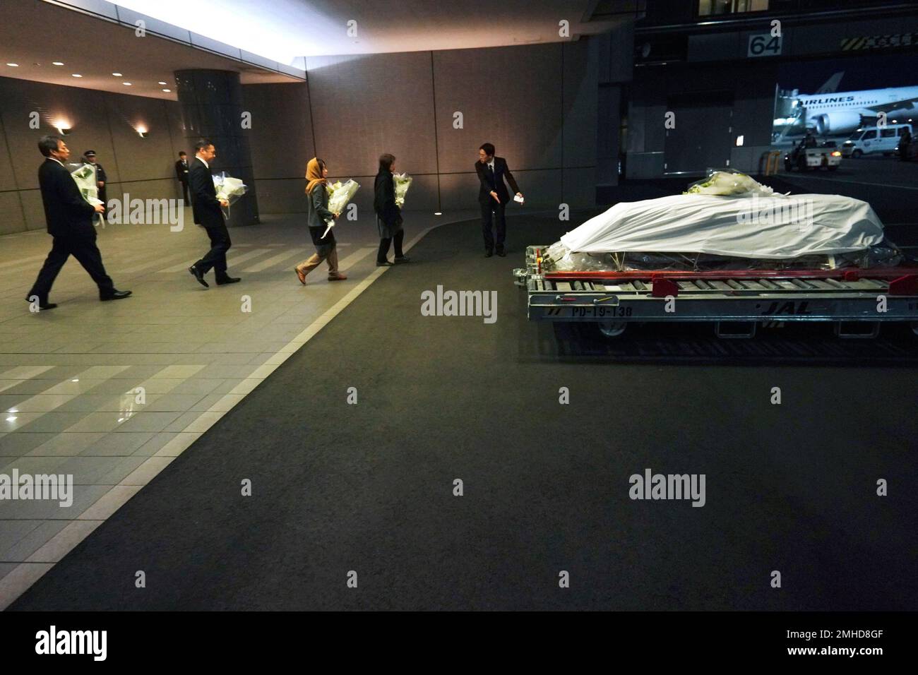 Family members and officials walk to lay flowers at the coffin of slain ...