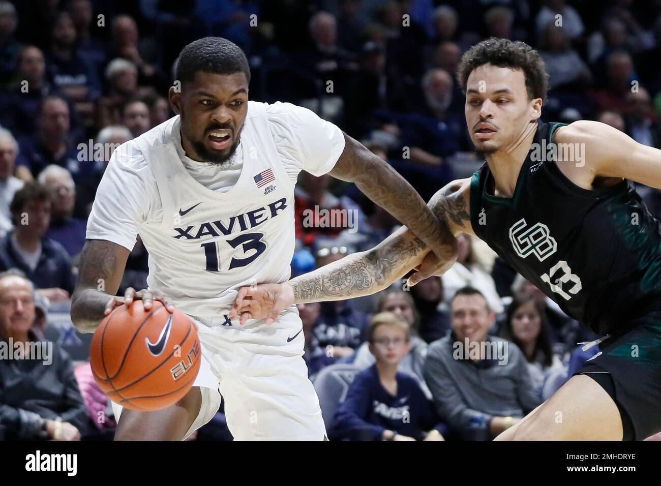 Xavier's Naji Marshall, left, drives against Green Bay's Trevian Bell ...