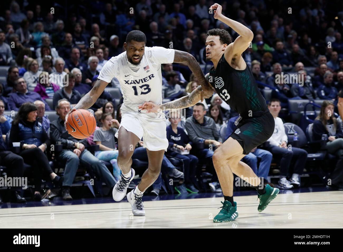 Xavier's Naji Marshall, left, drives against Green Bay's Trevian Bell ...