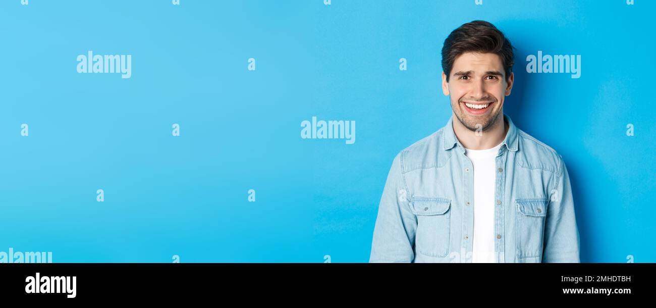 Close-up of young man feeling awkward, smile and cringe from ...