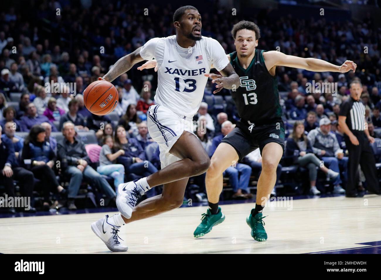 Xavier's Naji Marshall, left, drives past Green Bay's Trevian Bell ...