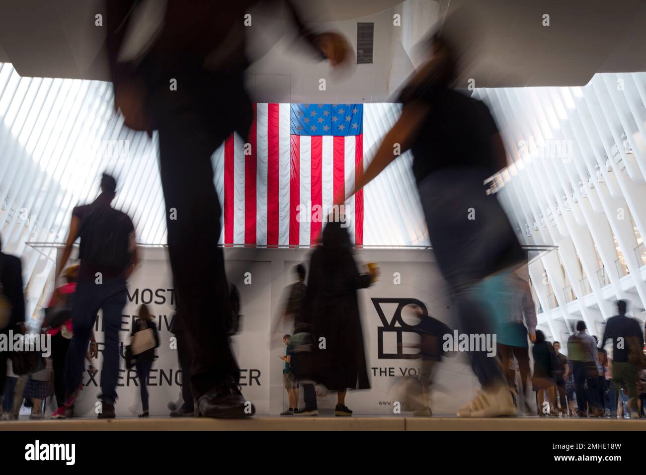 FILE - In this Sept. 11, 2019, photo people walk past an American flag ...