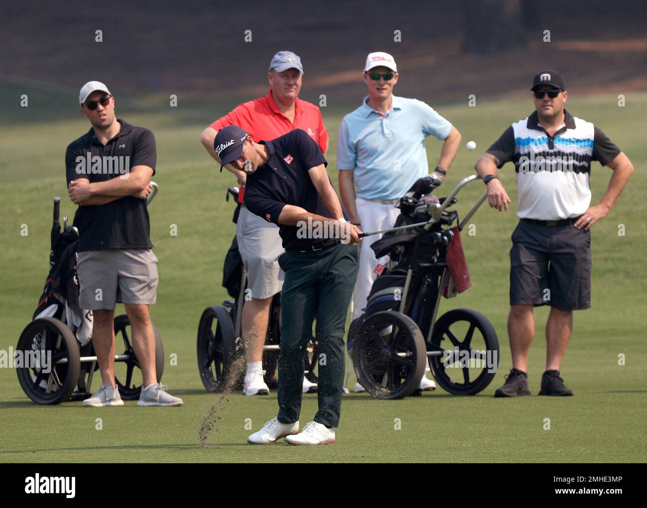 Australia's Adam Scott, center, hits his second shot on the 12th hole ...