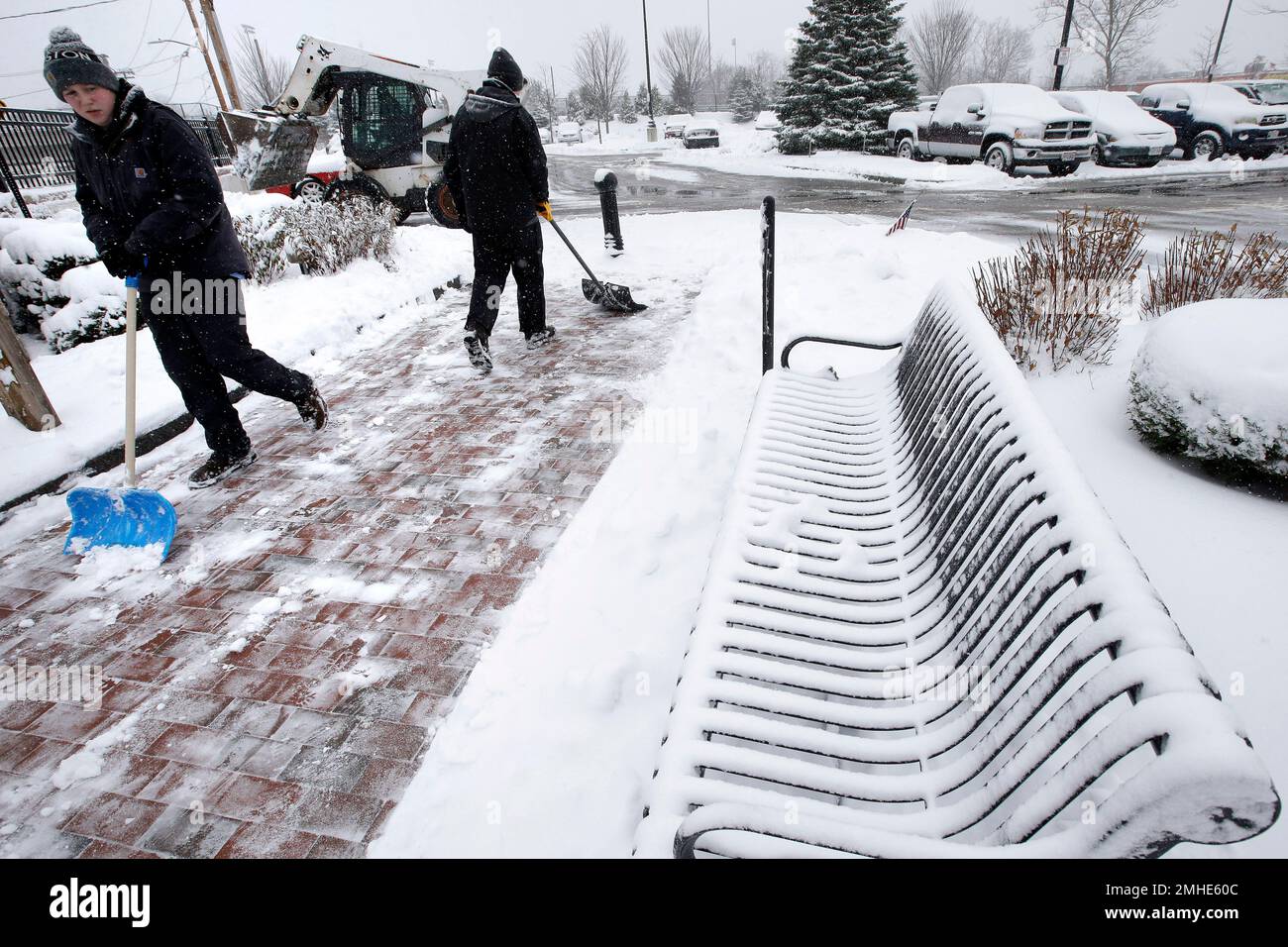 Workers shovel a sidewalk, Tuesday, Dec. 3, 2019, in Dedham, Mass. (AP ...