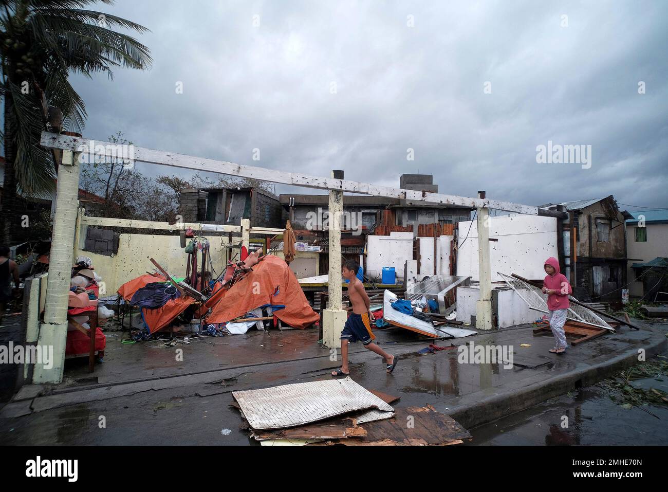 Children pass by damaged homes due to strong winds as Typhoon Kammuri ...