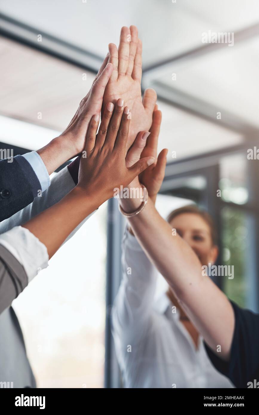 We did it. a group of unrecognizable businesspeople high fiving in the ...
