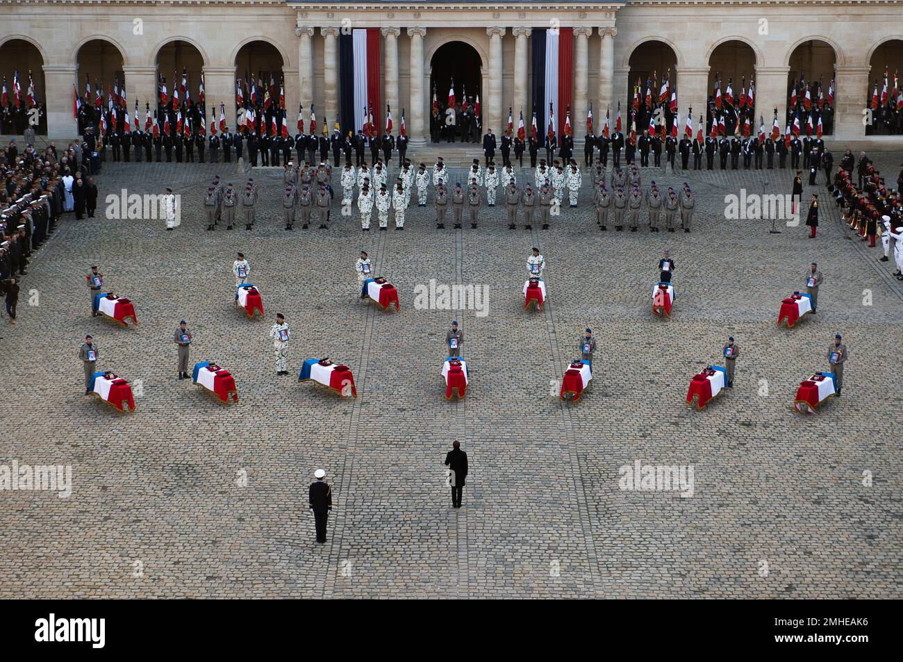 French President Emmanuel Macron stands in front of the coffins of the ...