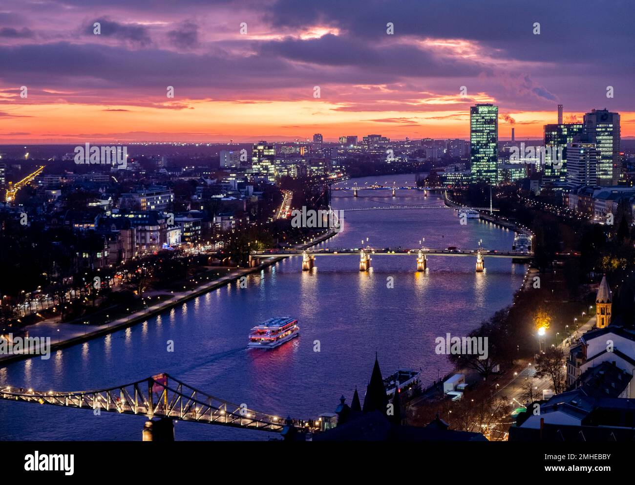An illuminated party ship cruises over the river Main after sunset in ...