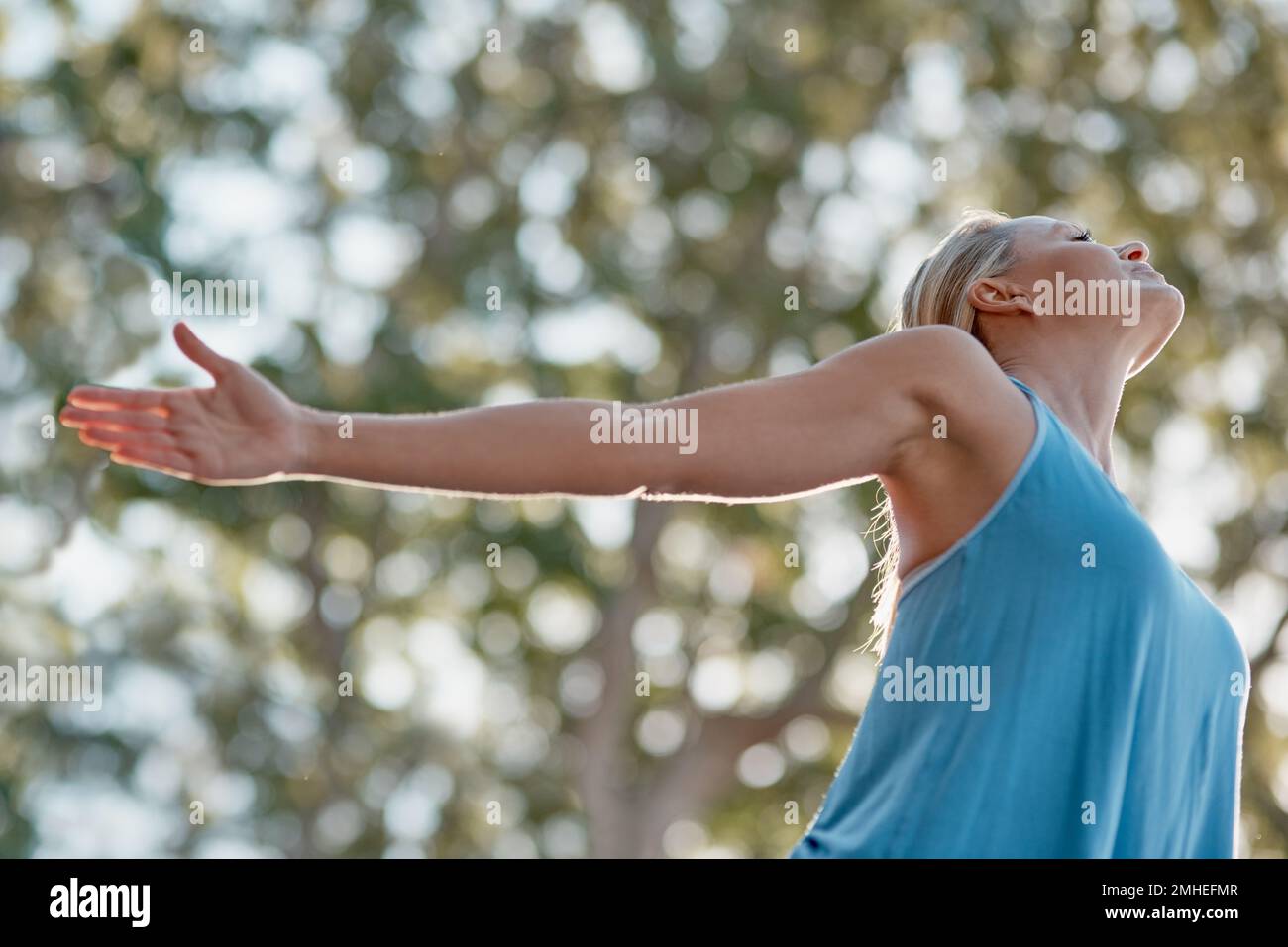 Greet the world with peace everyday. a mature and fit woman standing ...