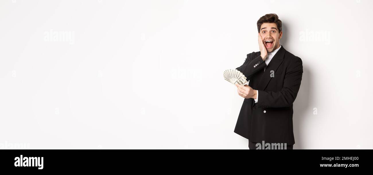 Image of rich and happy man in black suit, winning prize, holding money ...