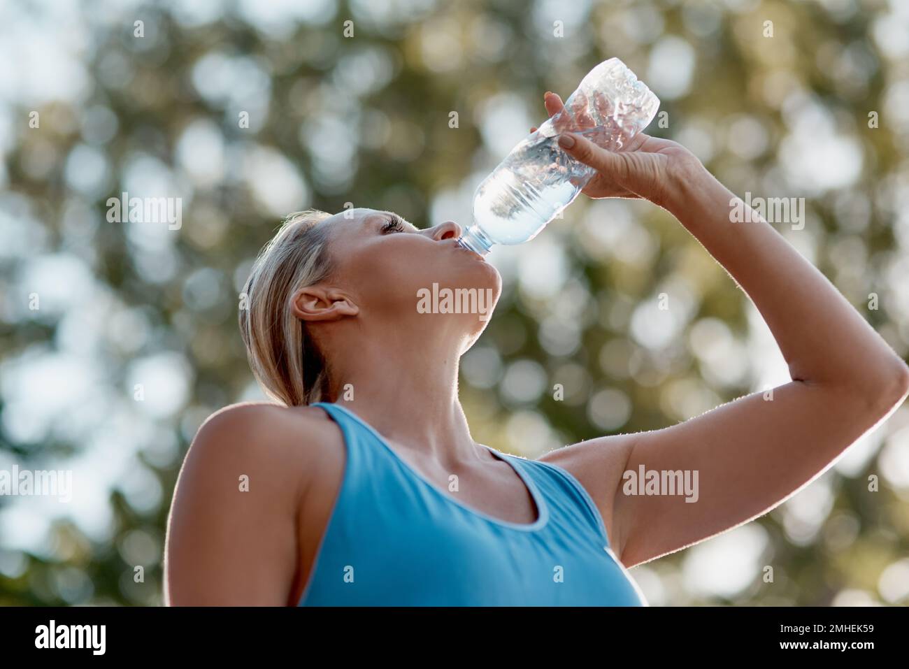 Hydrating is very important. mature and fit woman having a drink from a water bottle in the ...
