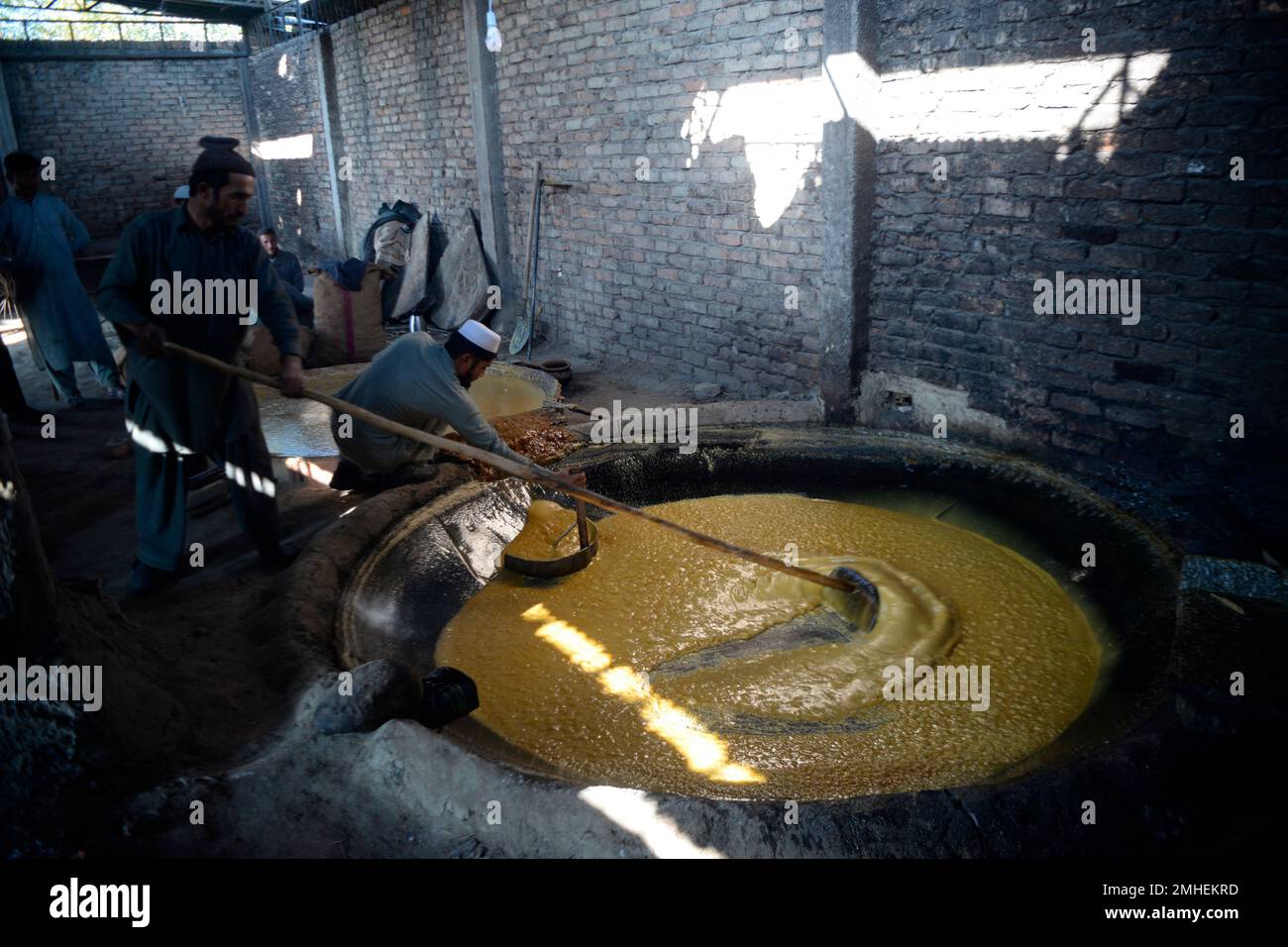 Pakistani farmers boil sugarcane juice to make a traditional sweet ...