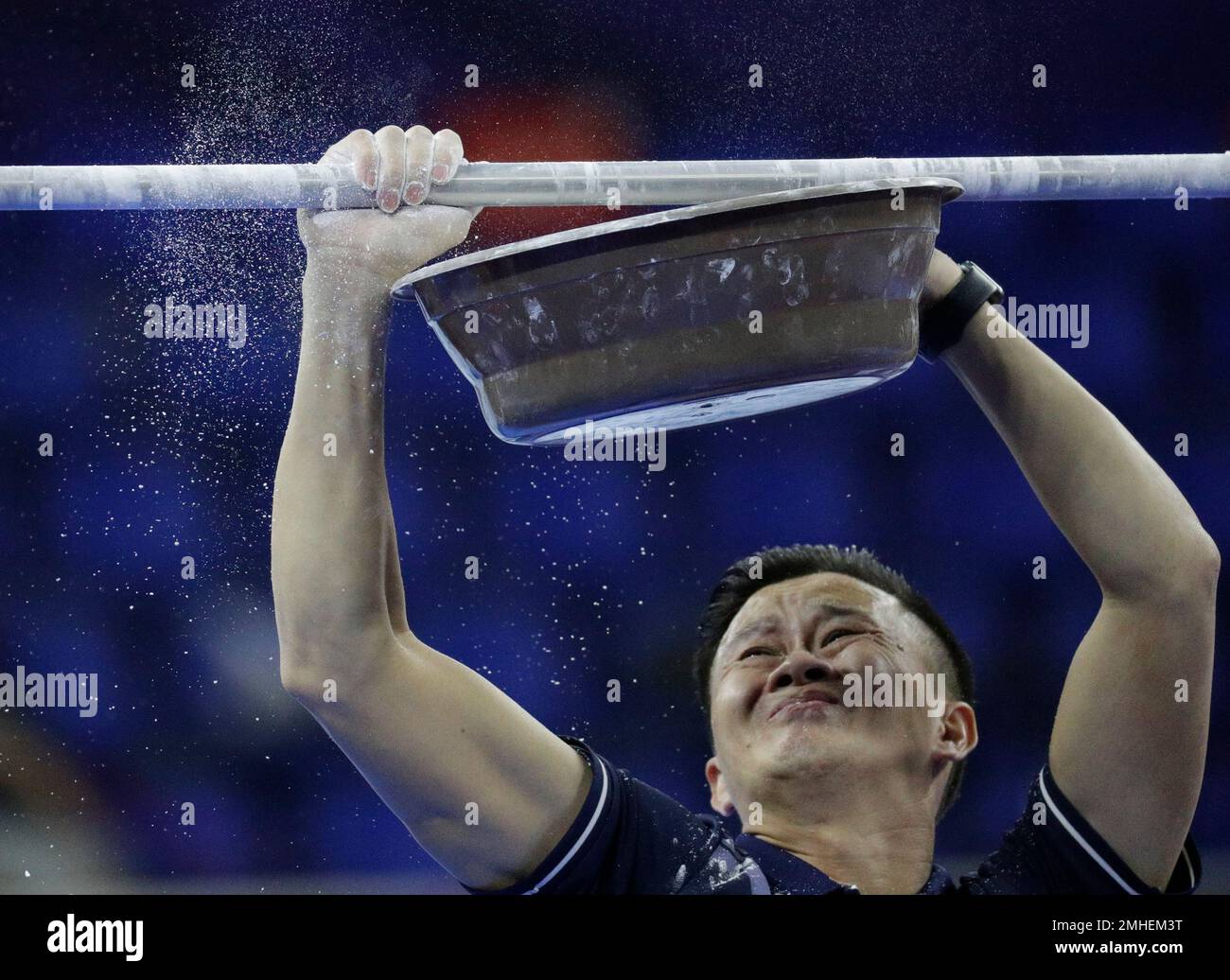 A man from the Vietnam team puts powder on the bars during the men's ...