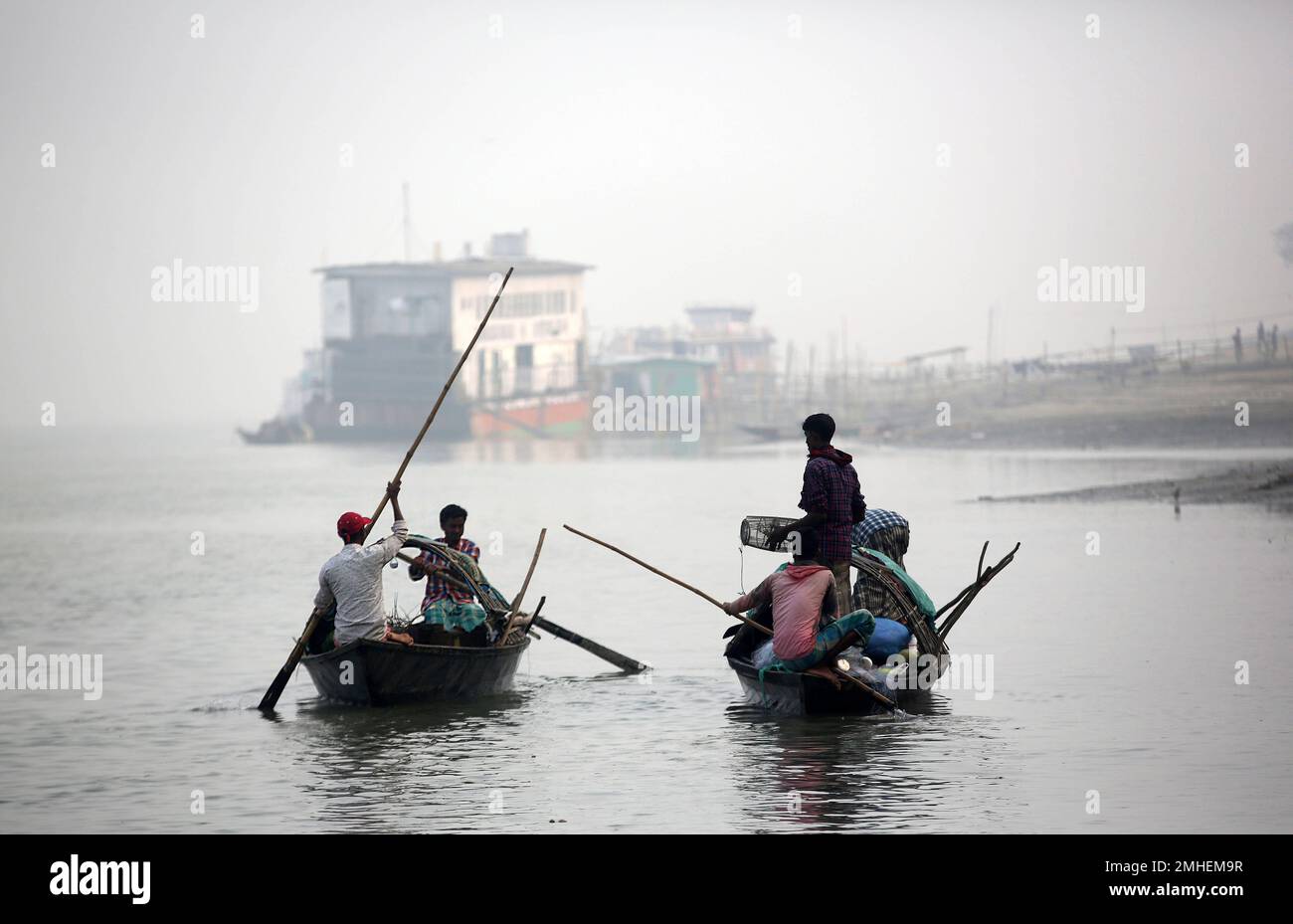 Indian fishermen row boats to catch fish in the river Brahmaputra in ...