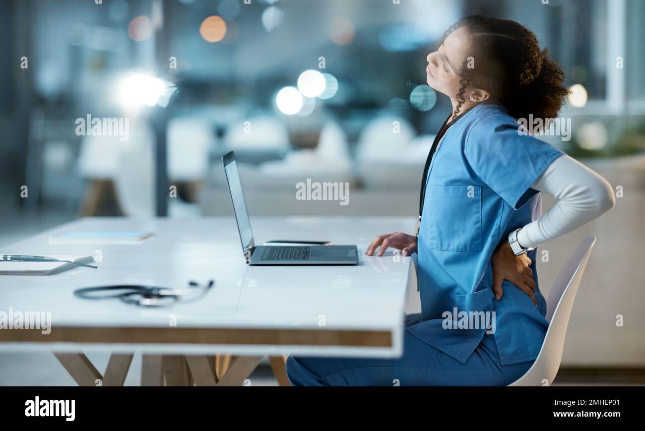 Laptop, back pain and doctor in her office at the hospital working on a ...
