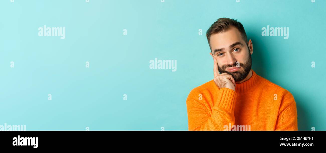 Close-up of unamused sad man looking at camera, pouting and leaning ...