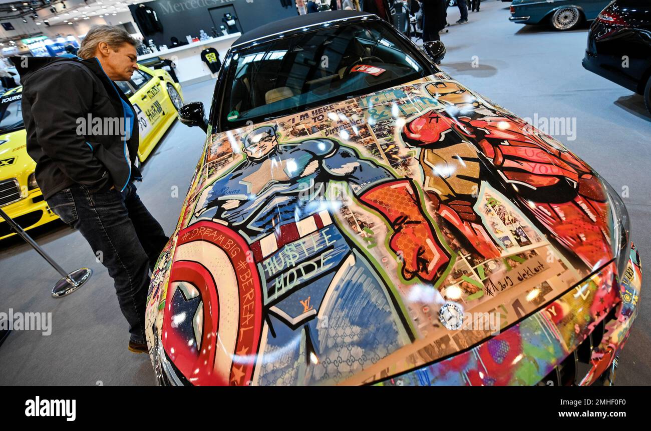 A visitor watches a custom made Mercedes car with a comic art bonnet at ...