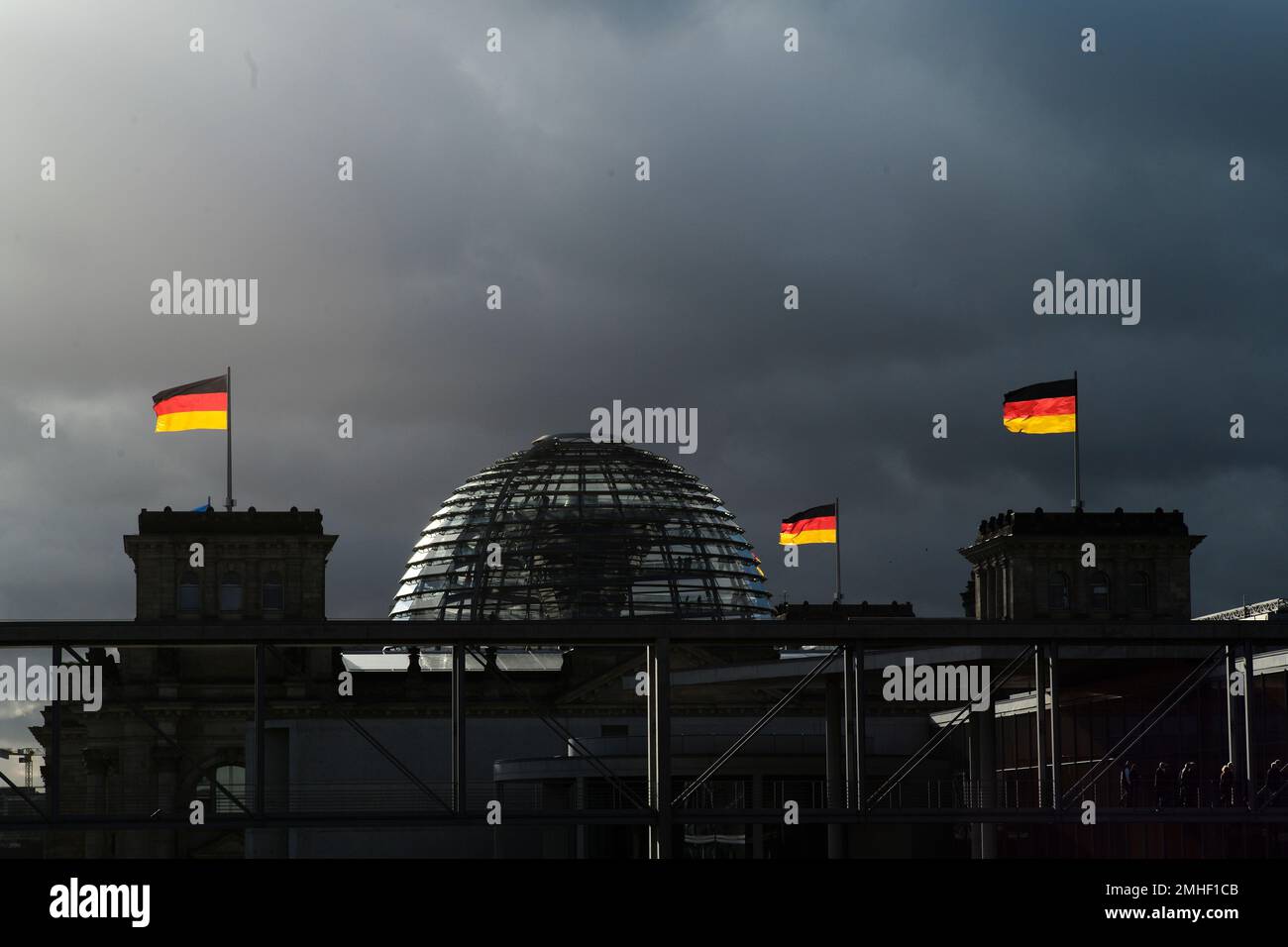 German national flags catch the sun on top of the German parliament ...