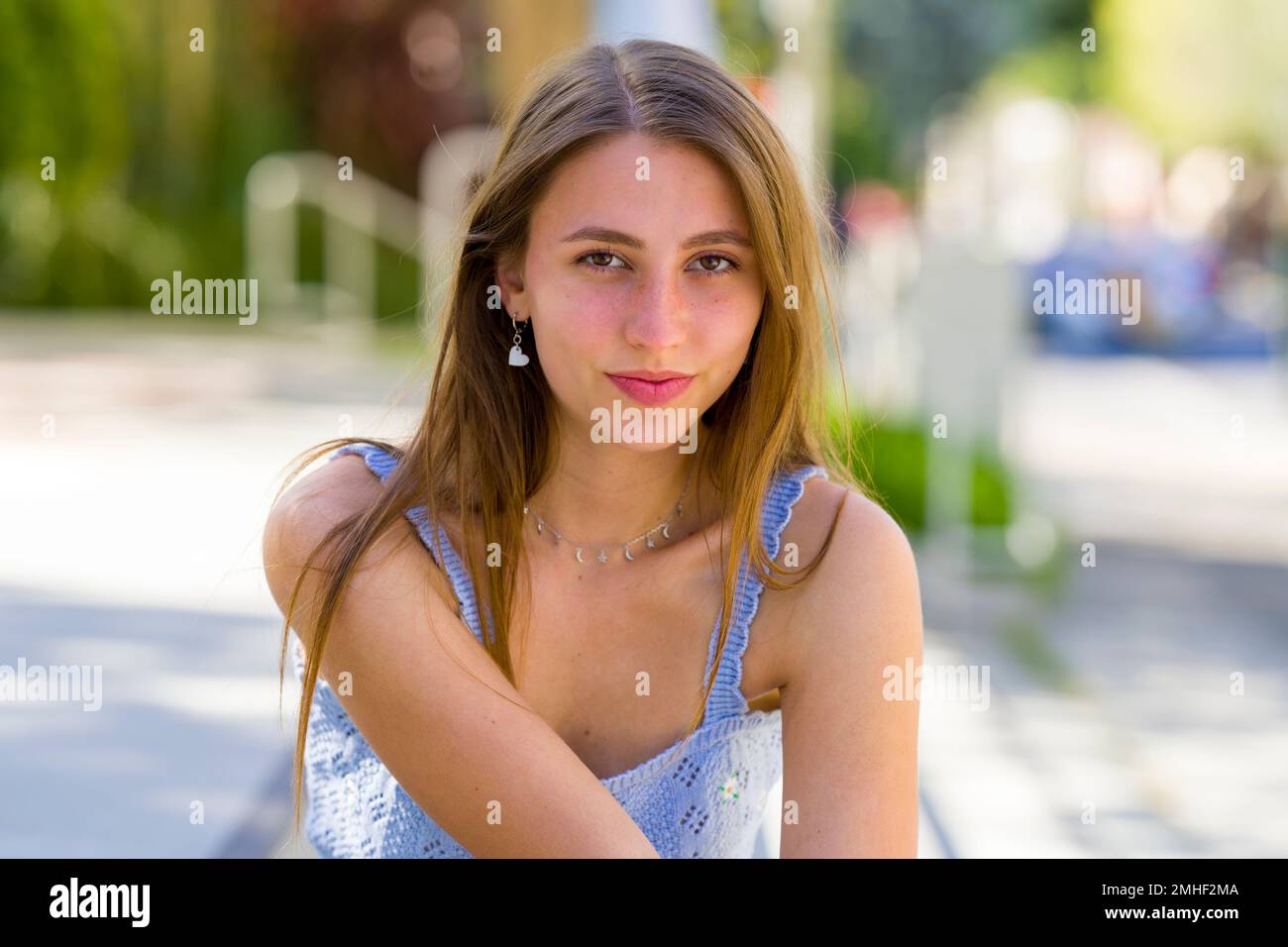 Close Up of Teenage Girl Smiling Sitting and Leaning Towards Camera on ...