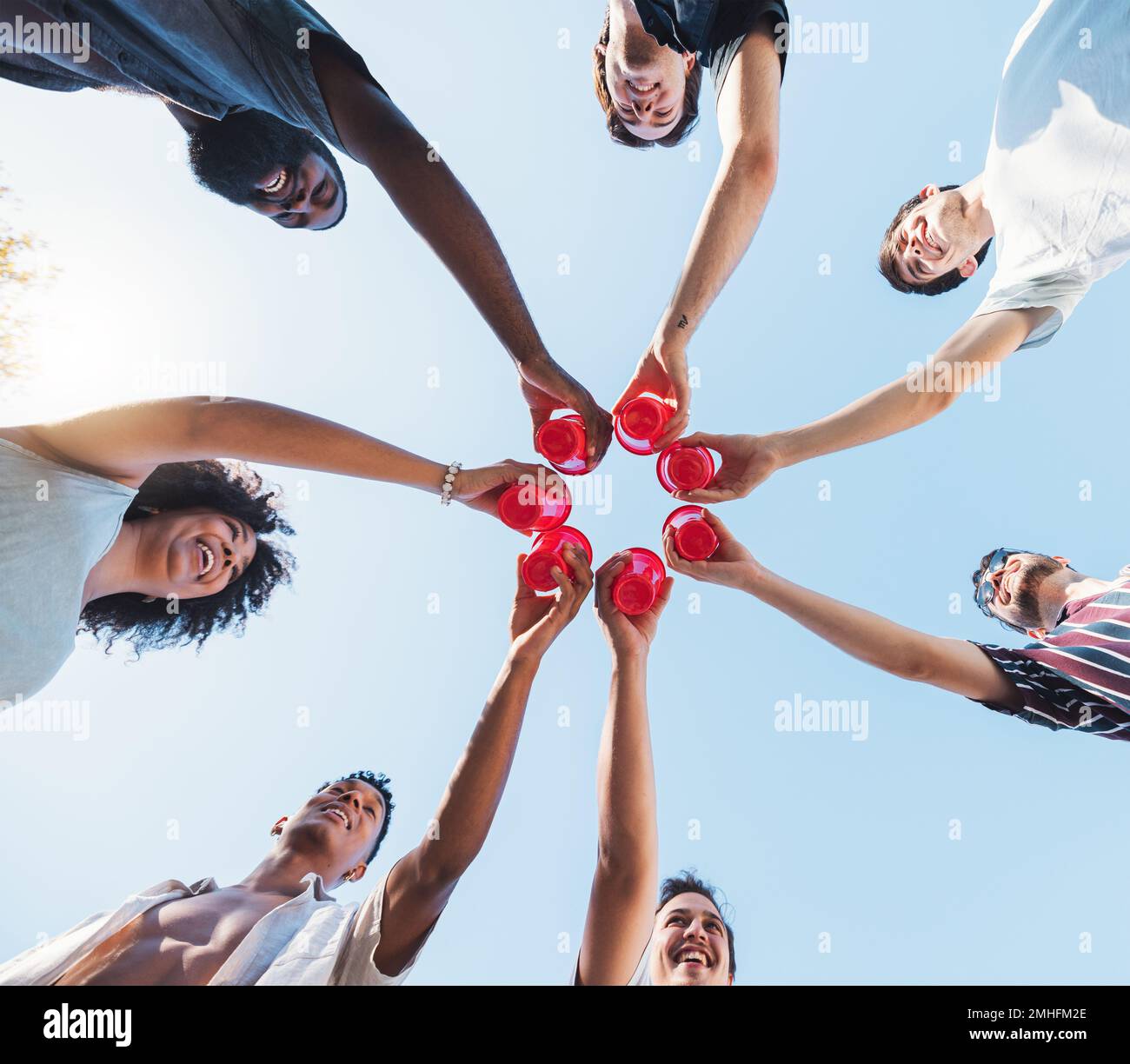 Cheers, sky and alcohol with a group of friends making a toast together ...