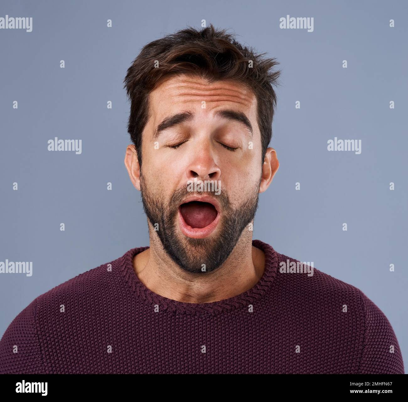 Is this day over yet. Studio shot of a handsome young man yawning ...