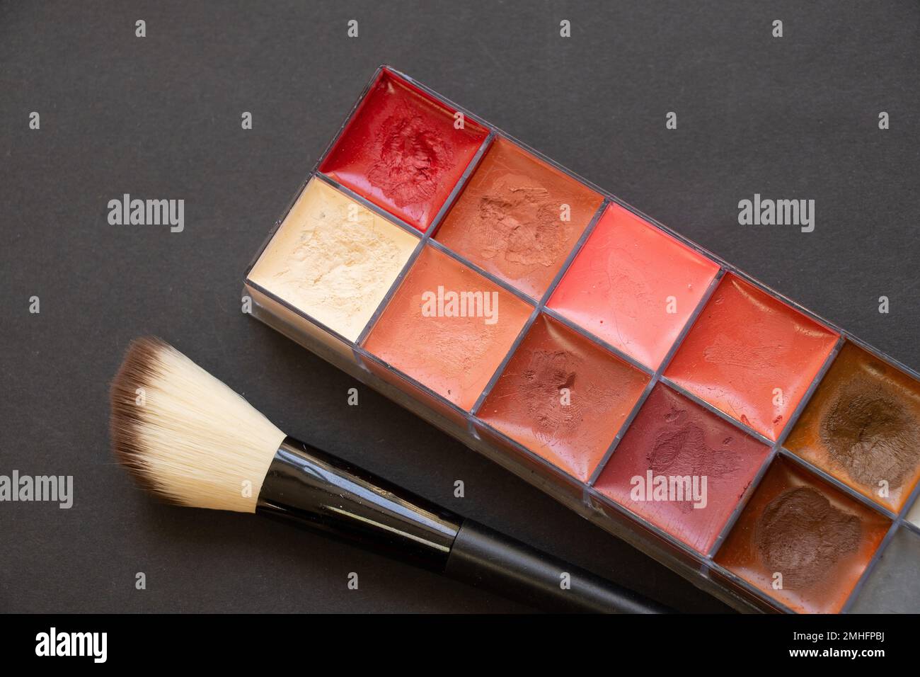 multi-colored eyeshadows for make-up and brushes on a dark background ...