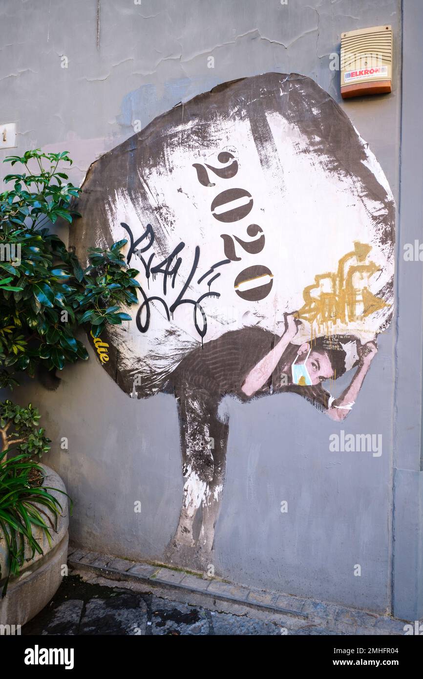 A paper poster, depicting a young man with a mask, hauling a huge bag ...
