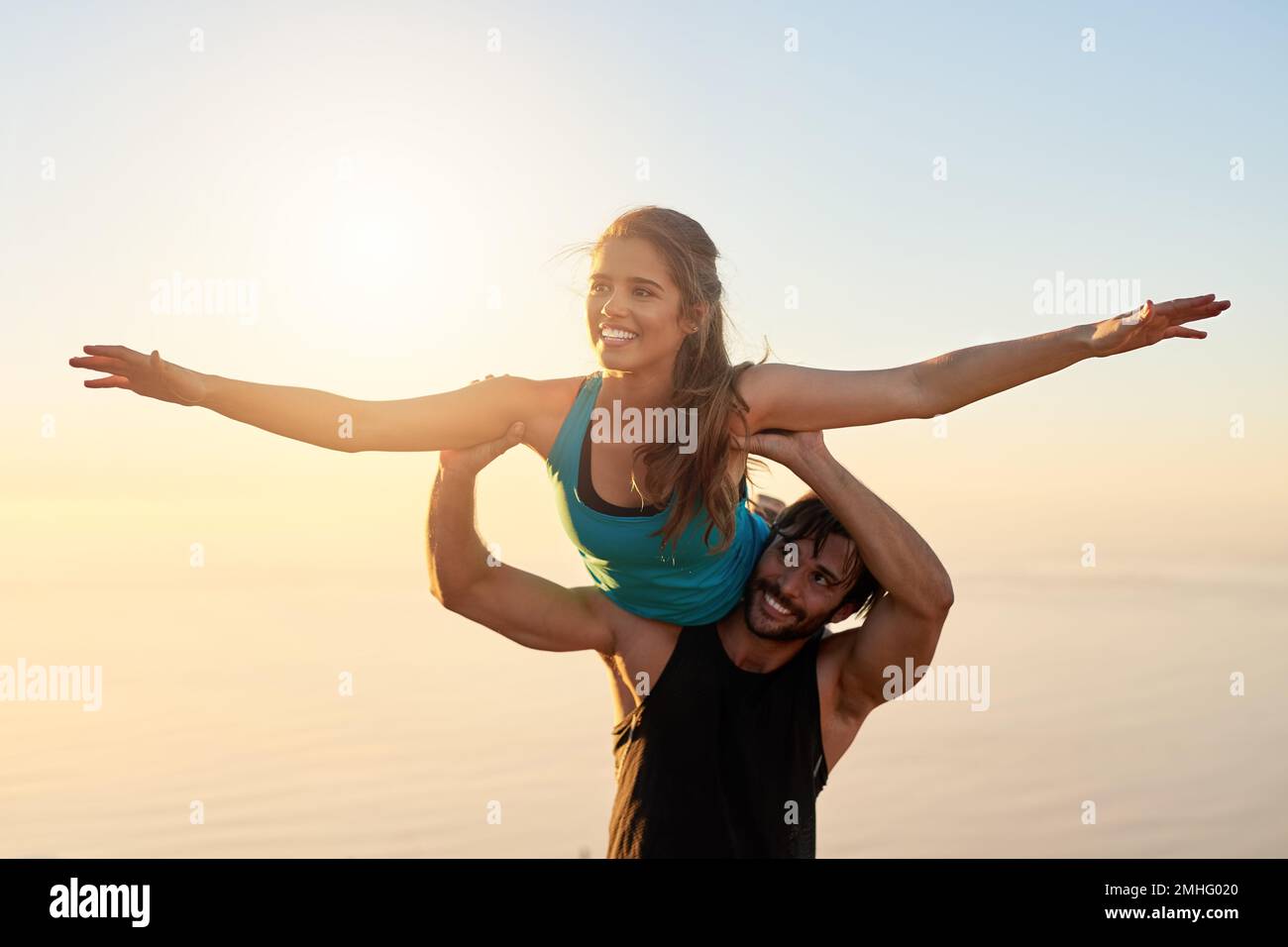 Couples should uplift each other. a sporty couple being playful while ...