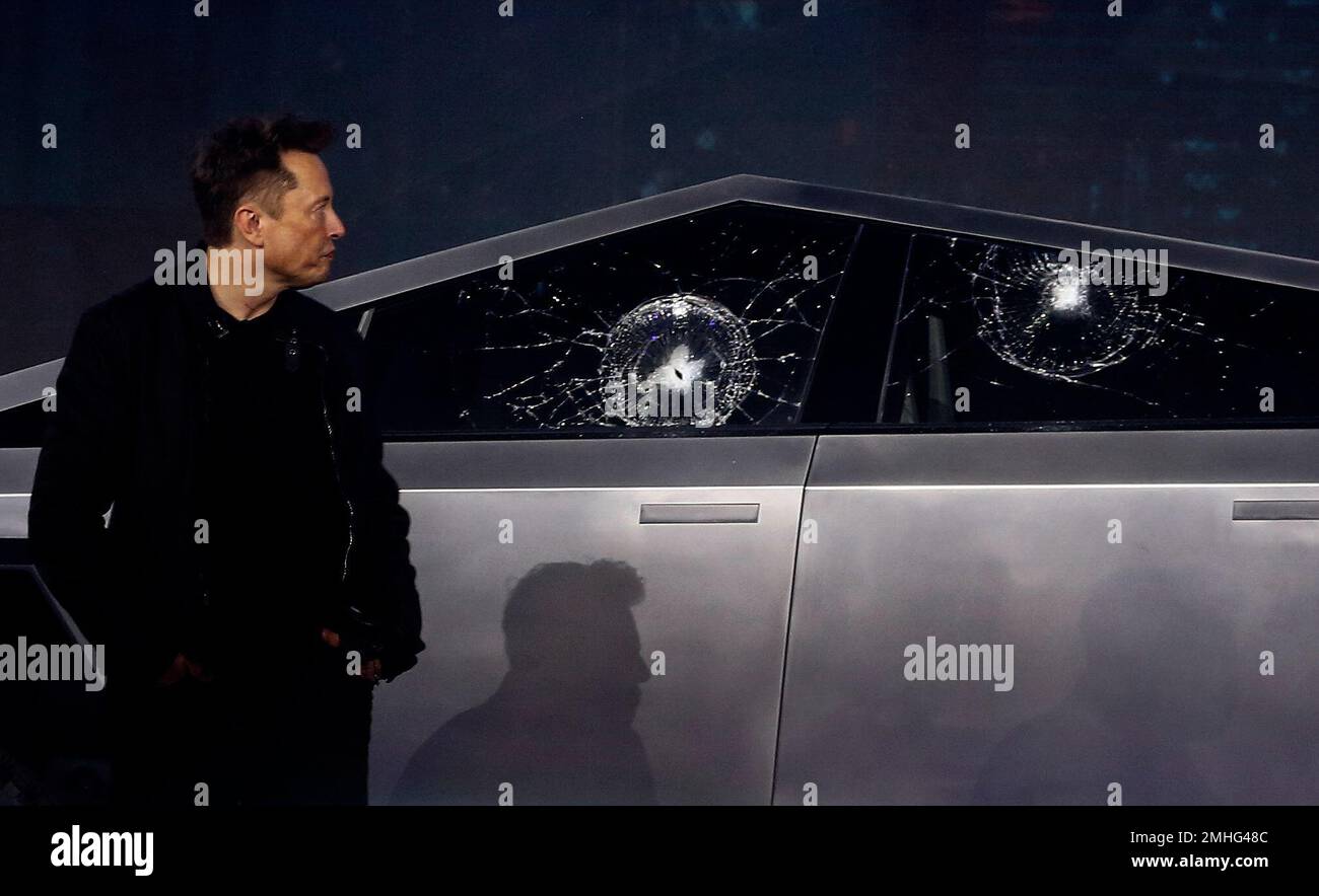 Tesla CEO Elon Musk looks at the broken window glass as he introduces ...