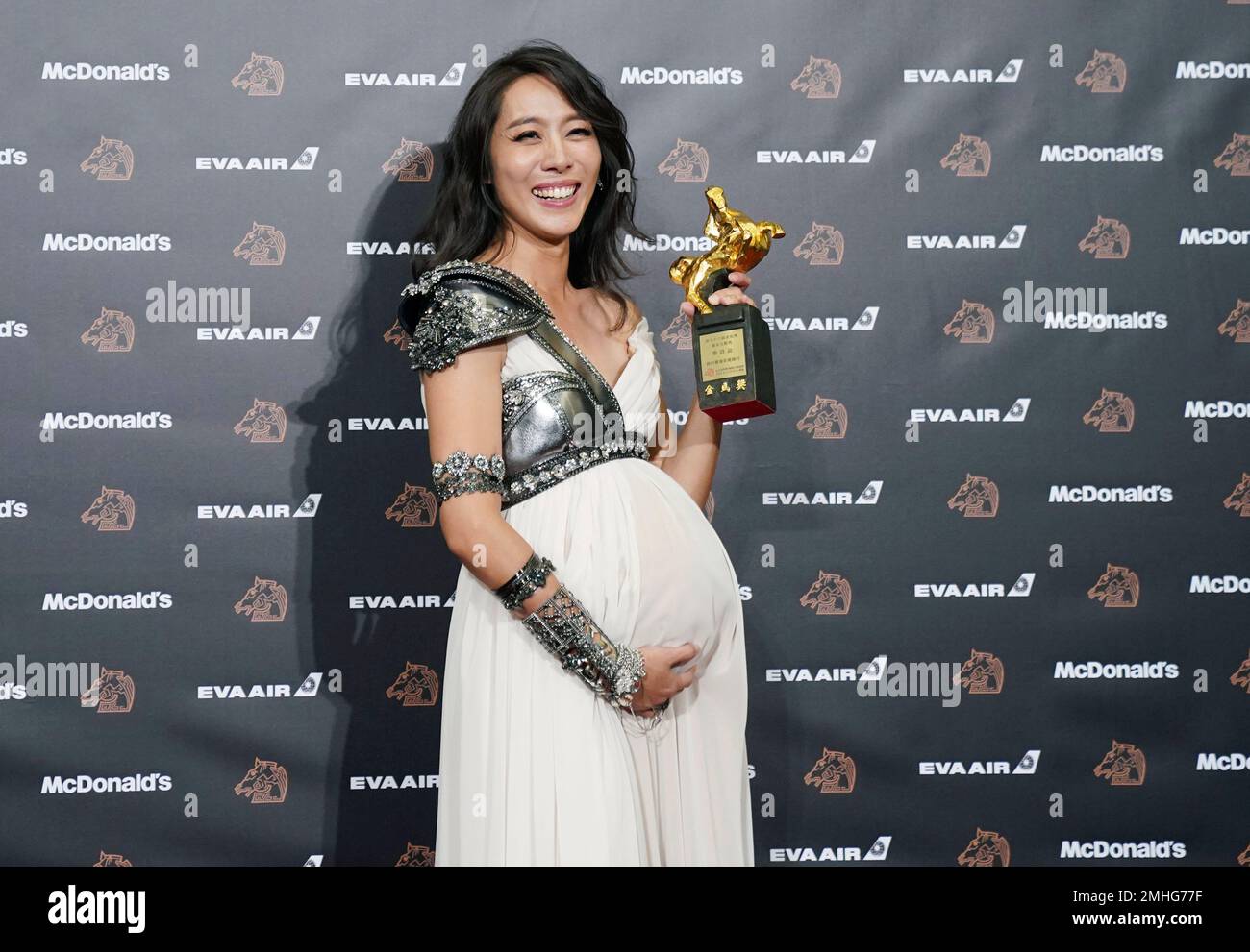Taiwanese actress Winnie Chang holds her award and poses for media for ...