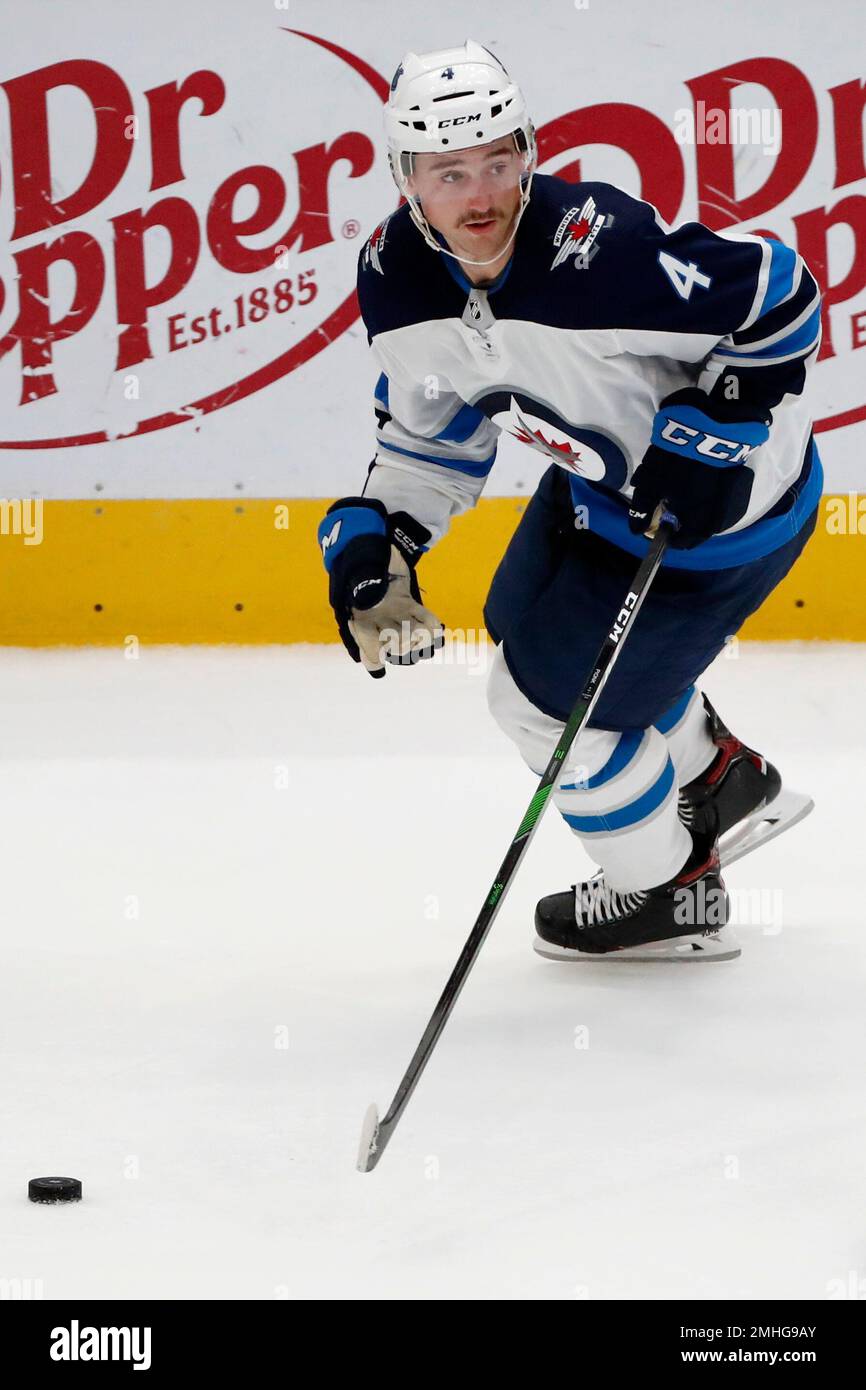 Winnipeg Jets defenseman Neal Pionk (4) controls the puck during an NHL ...