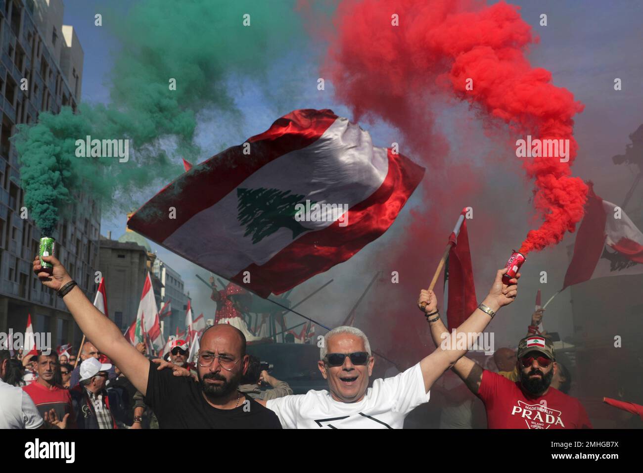 Anti-government protesters wave Lebanese national flags as hold smoke ...