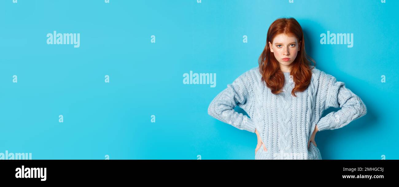 Redhead girl staring angry and displeased at camera, frowning upset ...