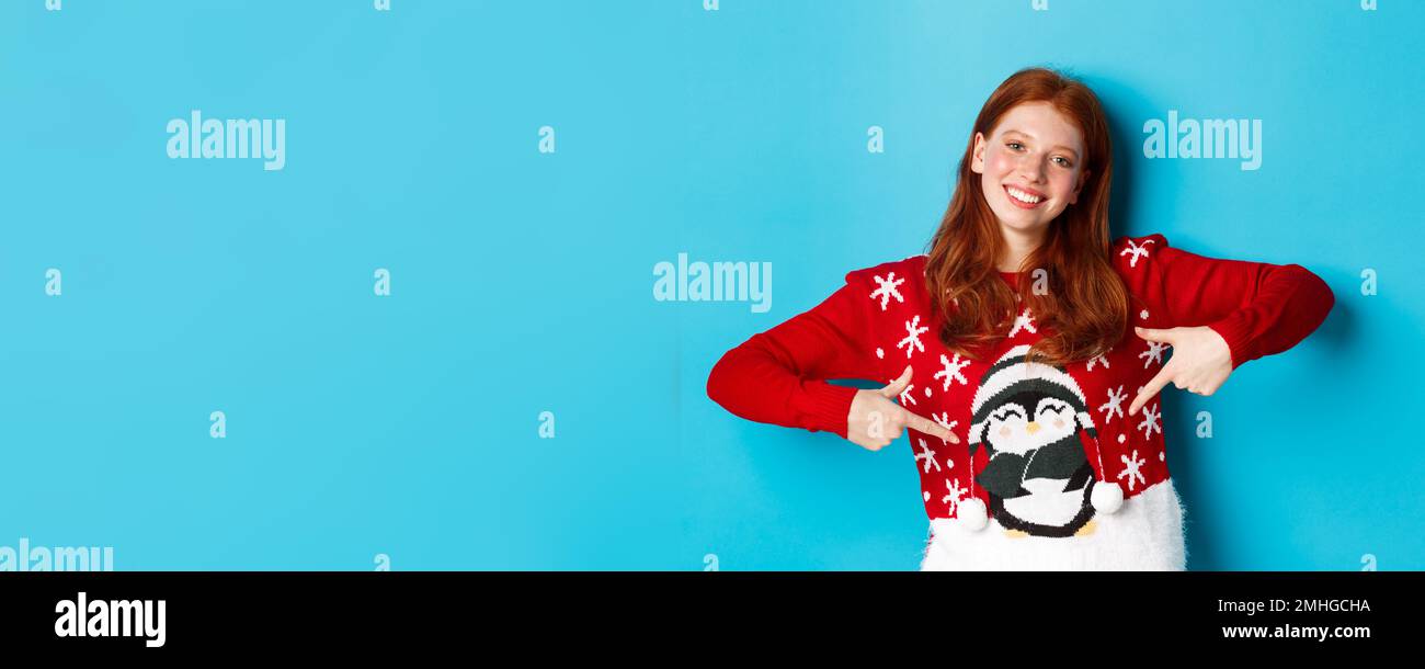 Winter holidays and Christmas Eve concept. Pretty redhead girl pointing ...