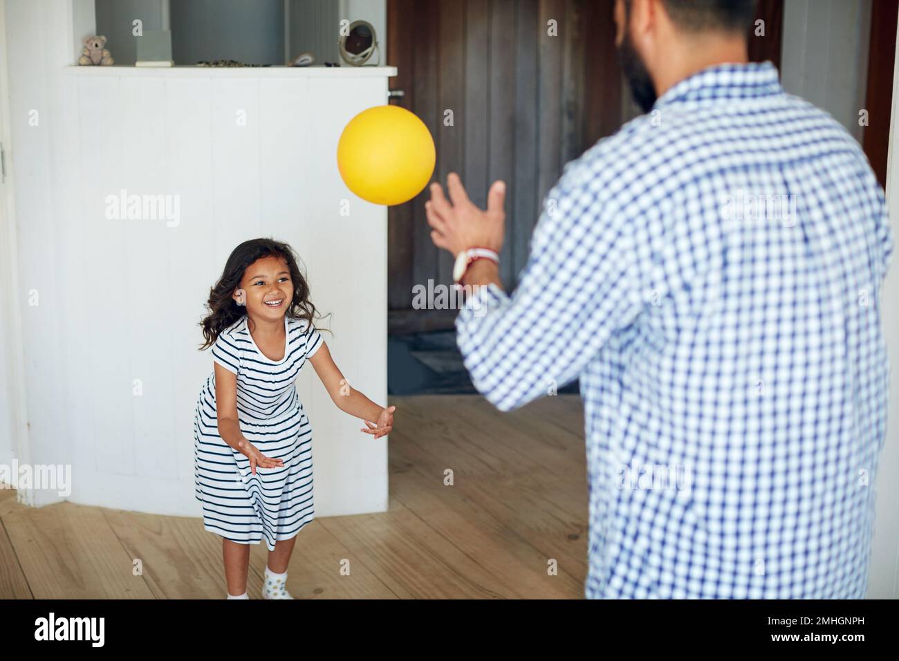 Now catch. a father and daughter having fun together at home Stock ...