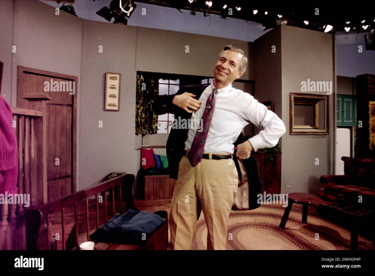 Fred Rogers puts on his jacket between takes on the set of his ...