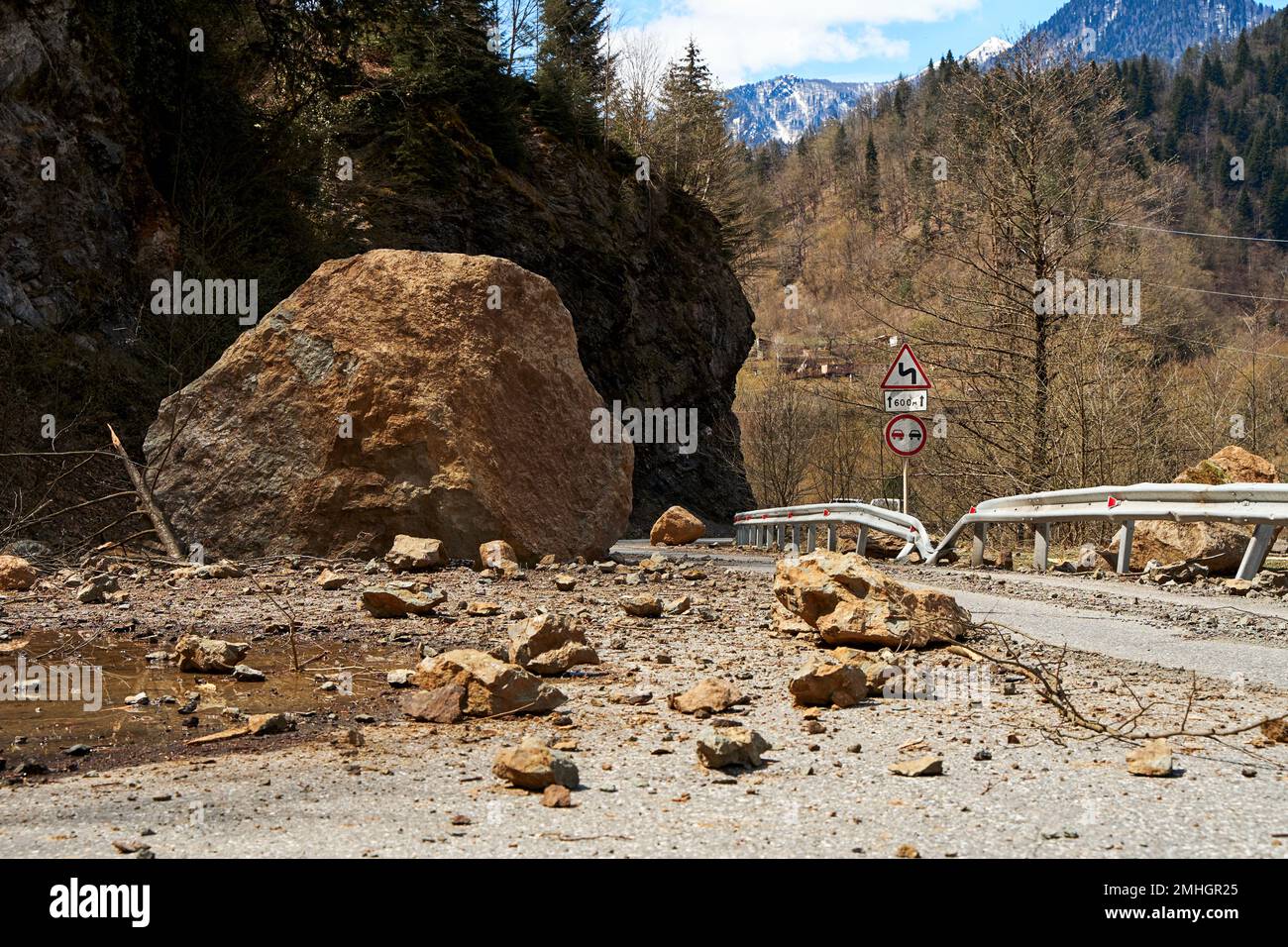 A huge rock fell from the mountains onto the road, destroying the ...