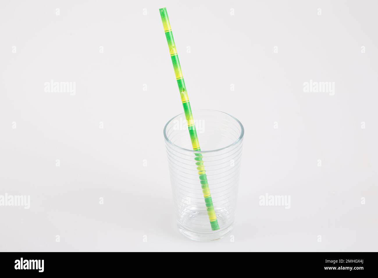 small glass transparent empty with green straw in carton recyclable ...