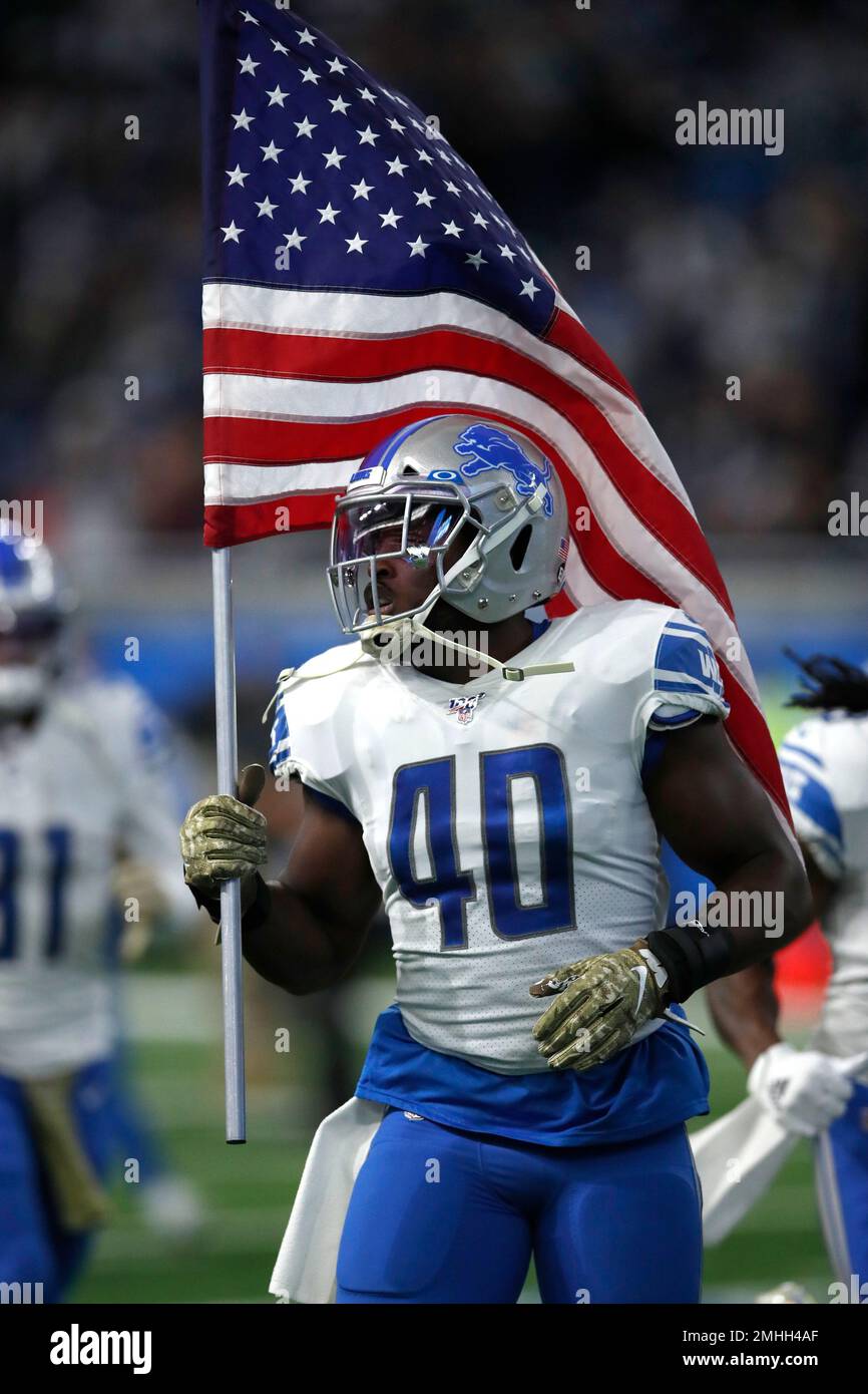 Detroit Lions linebacker Jarrad Davis (40) carries the flag onto the ...