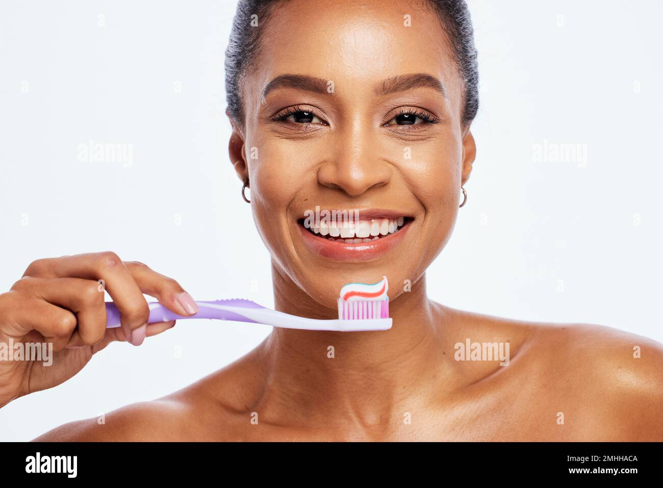 Portrait, cleaning and a black woman brushing teeth in studio isolated ...