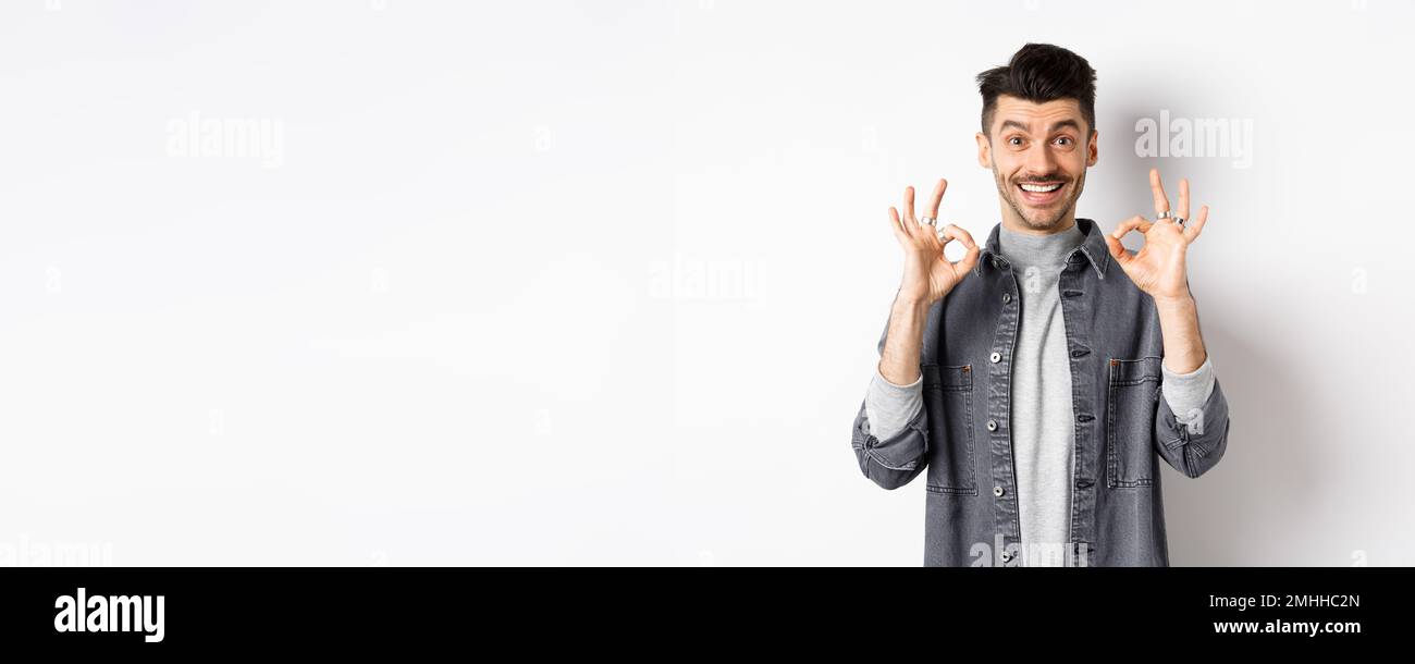 Happy guy say yes, smiling and showing okay signs, like good product ...