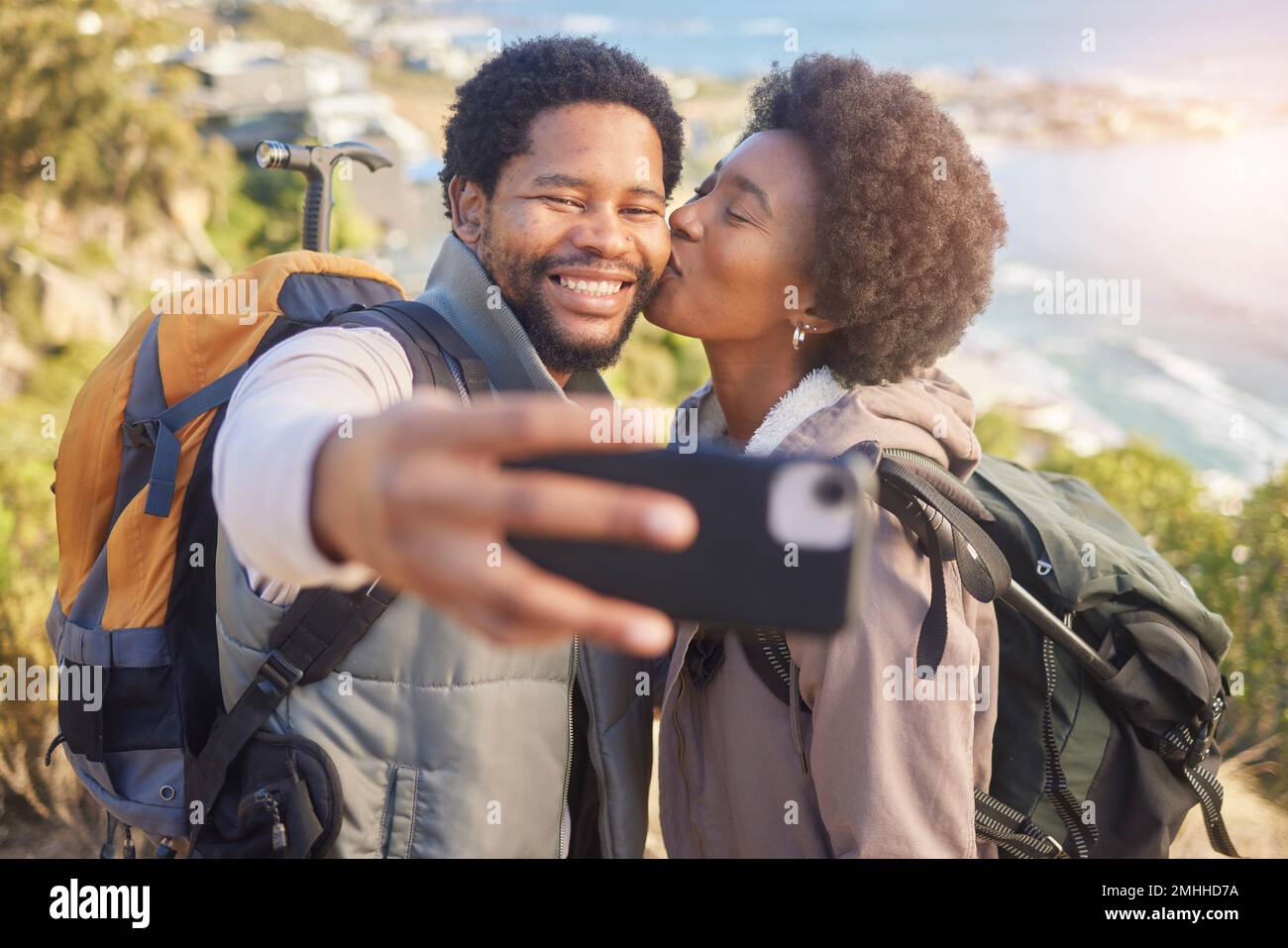 Selfie, kiss and black couple hiking on mountain for fitness, fun and ...