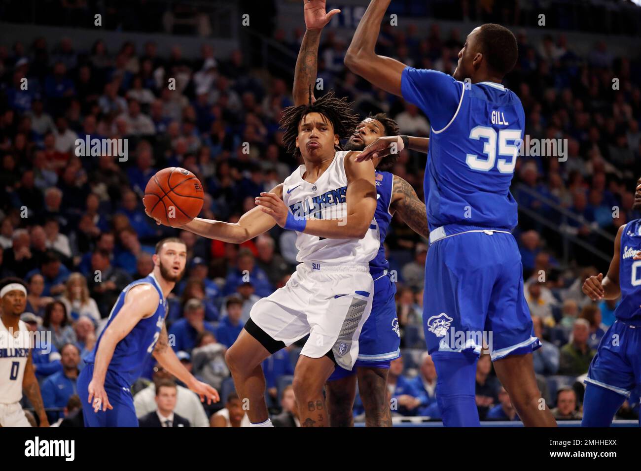 Saint Louis' Yuri Collins, left, passes around Seton Hall's Romaro Gill ...