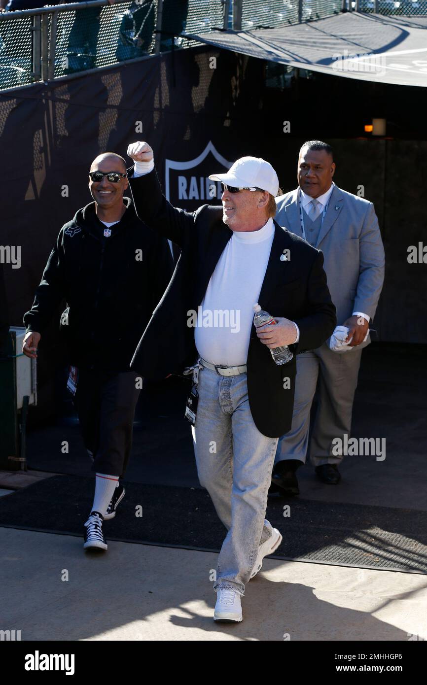 Oakland Raiders owner Mark Davis raises a fist walking onto the field ...