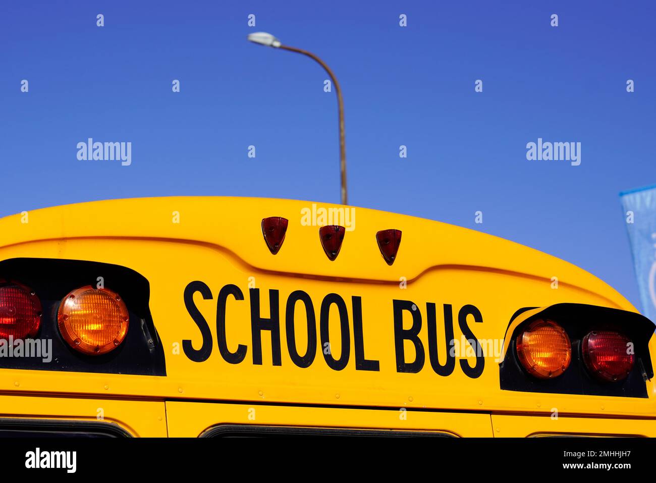 yellow school bus rear back closeup view with text sign and security ...
