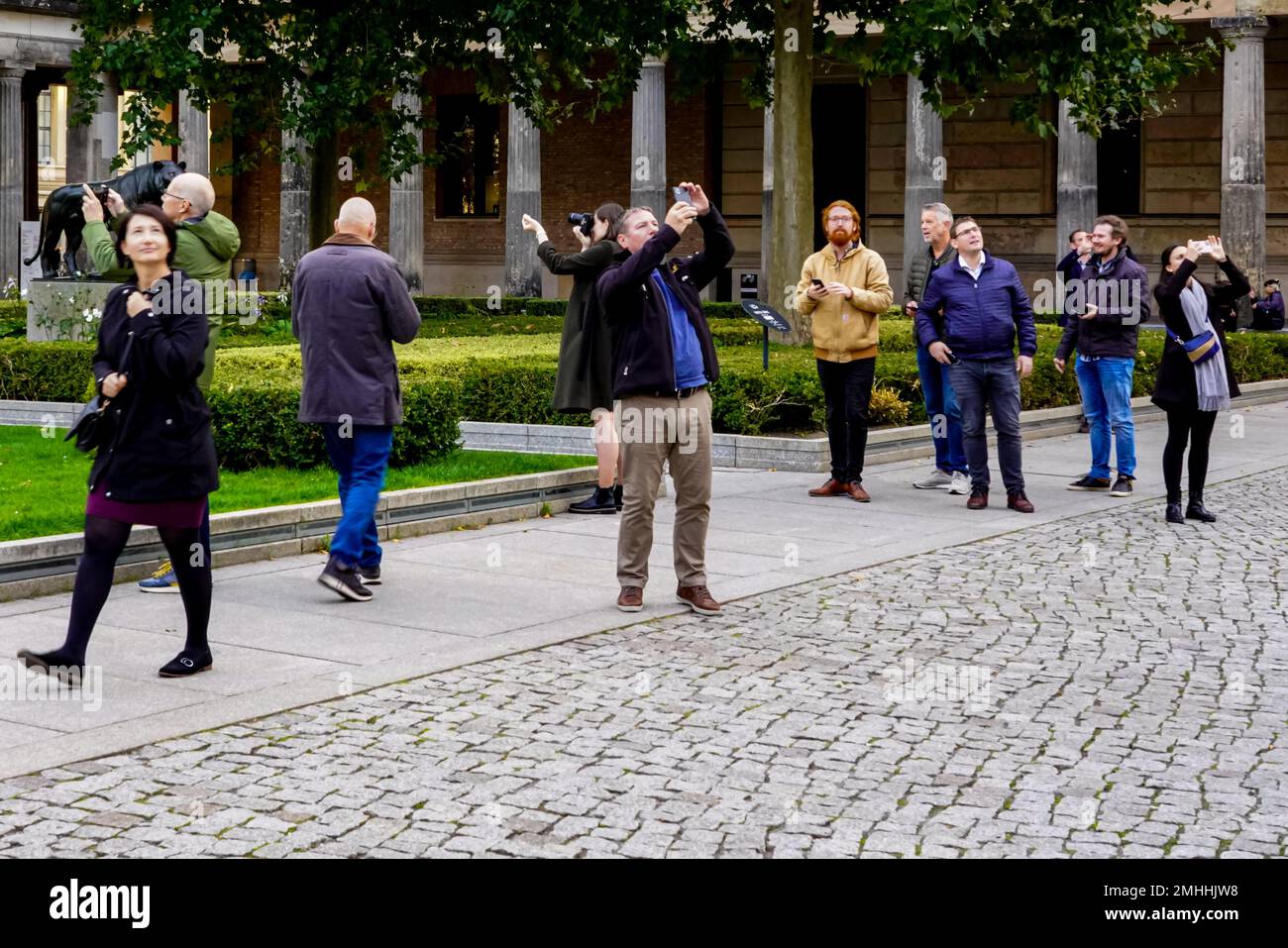 Group of amazed Tourists taking photos in the colonnade courtyard in ...