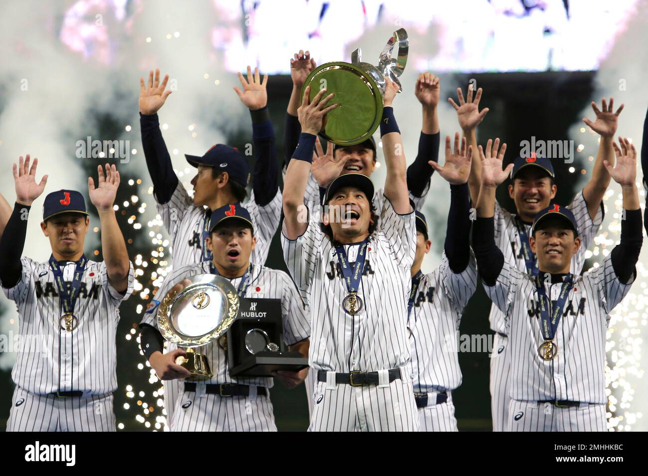 Japan's Nobuhiro Matsuda, third from left, raises the winner's trophy ...